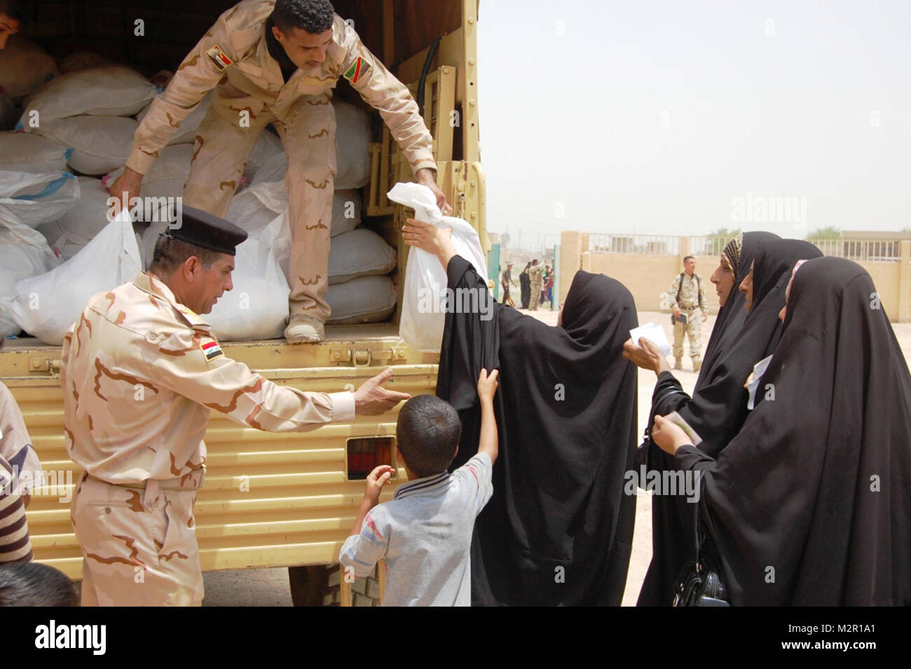 Soldiers with the 9th Iraqi Army Division Soldiers hand out bags ...
