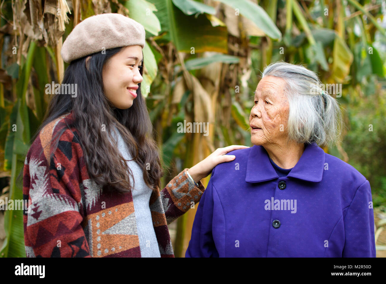 Asian girl spending time outdoors with her grandma in green tropical ...