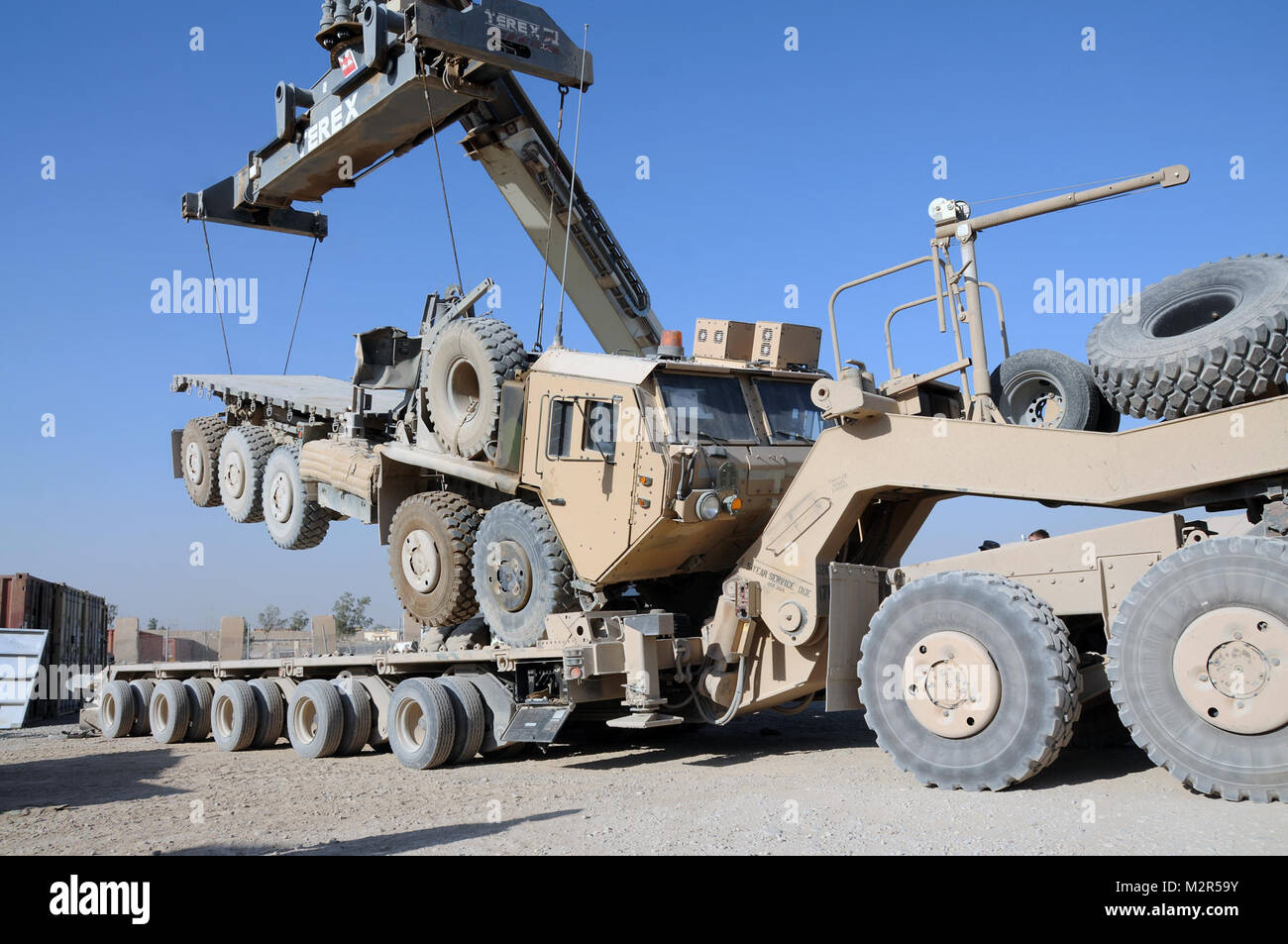 A Heavy Expanded Mobility Tactical Truck is being loaded onto a Heavy ...