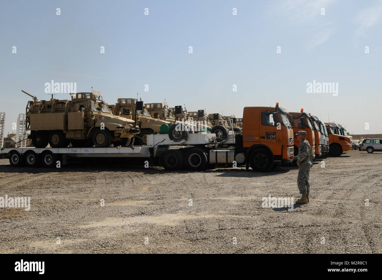 A convoy of flat bed trucks carrying mine resistance ambush protected ...