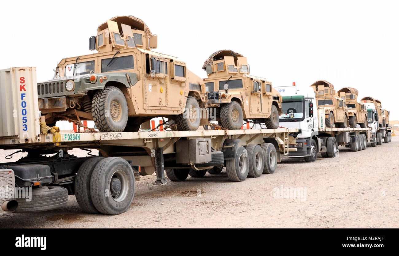 Flatbed trucks carrying high-mobility multipurpose wheeled vehicles are ...