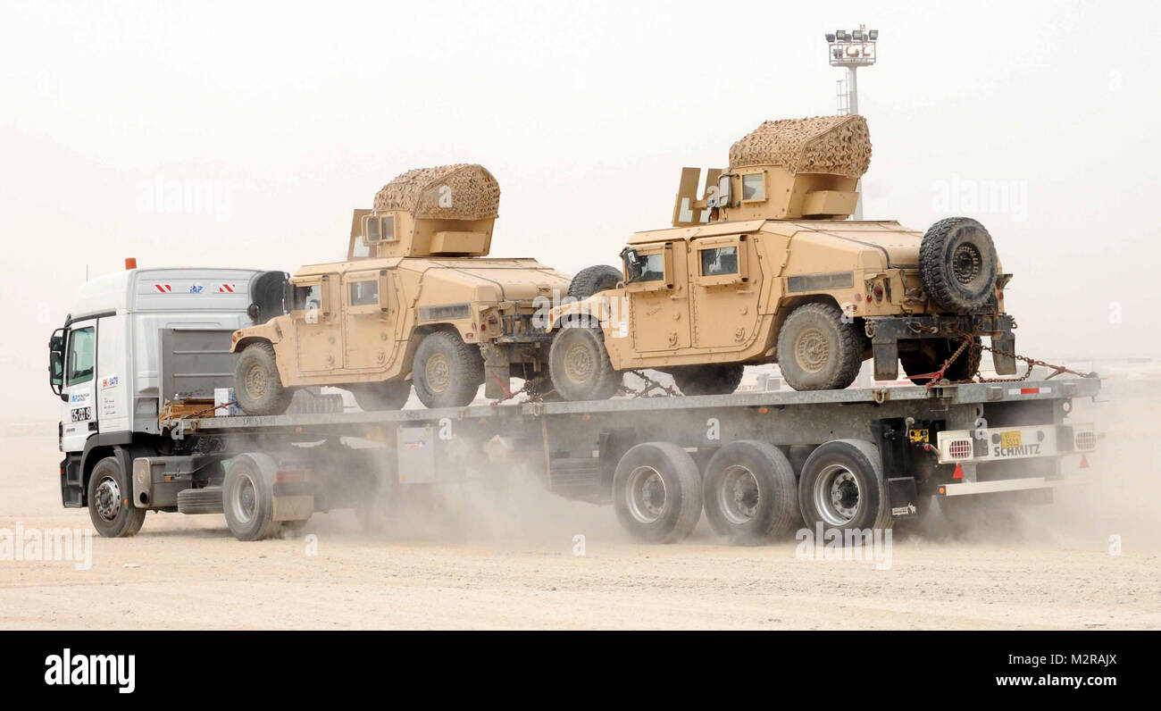 The first truck of a large convoy carrying military tactical vehicles ...