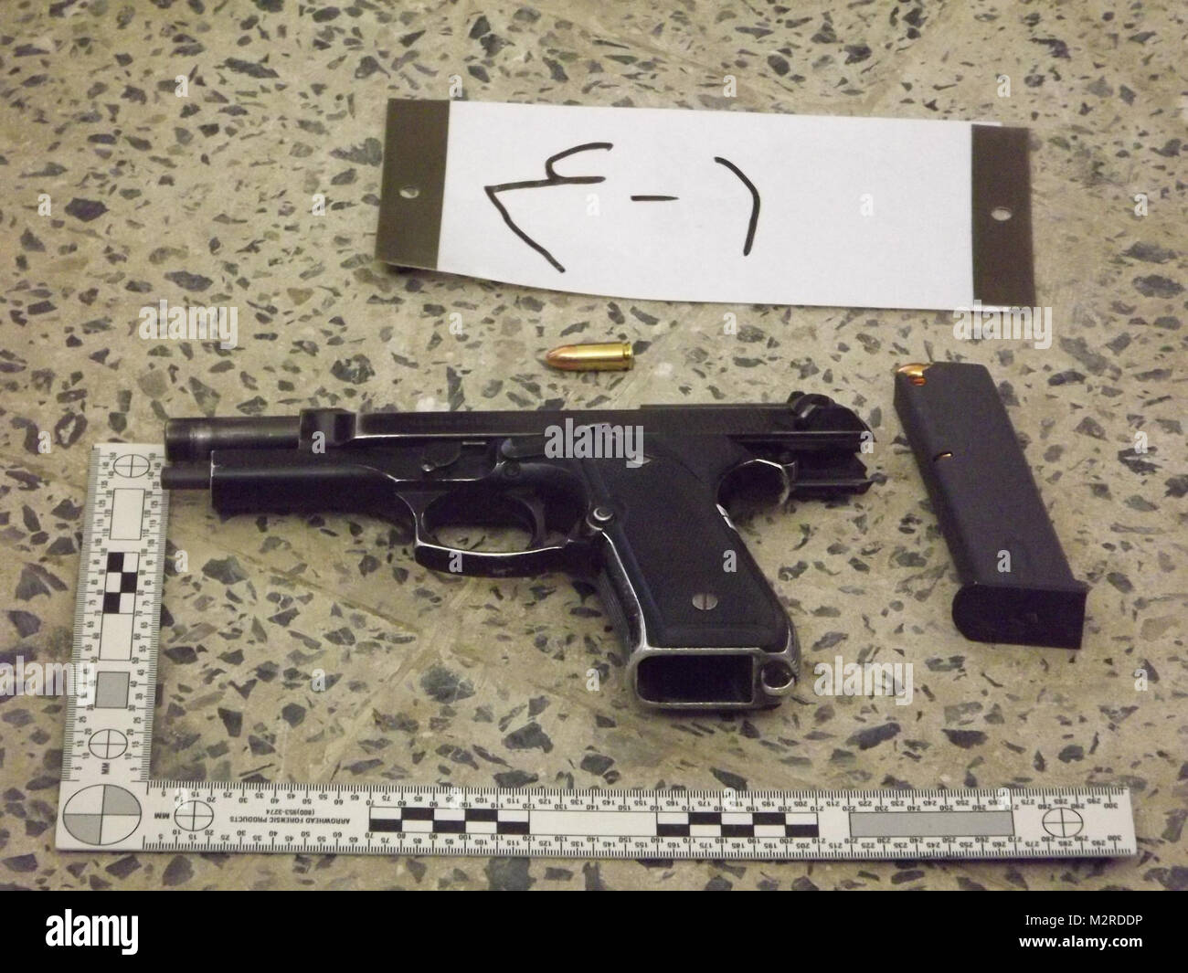 A 9mm pistol is measured and collected as evidence during a Crime Scene ...