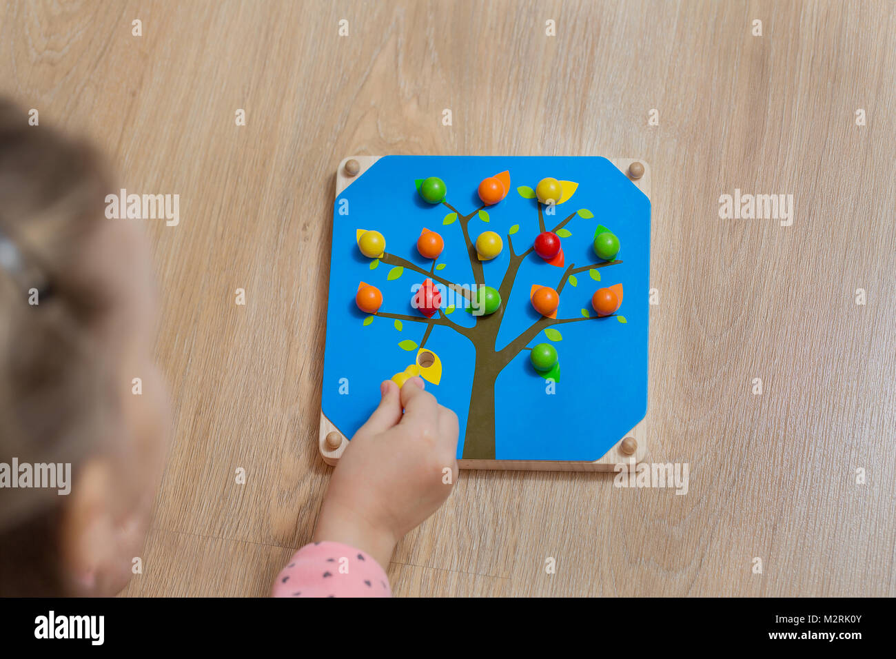 The child spreads the color of the wooden balls. Game for children ...