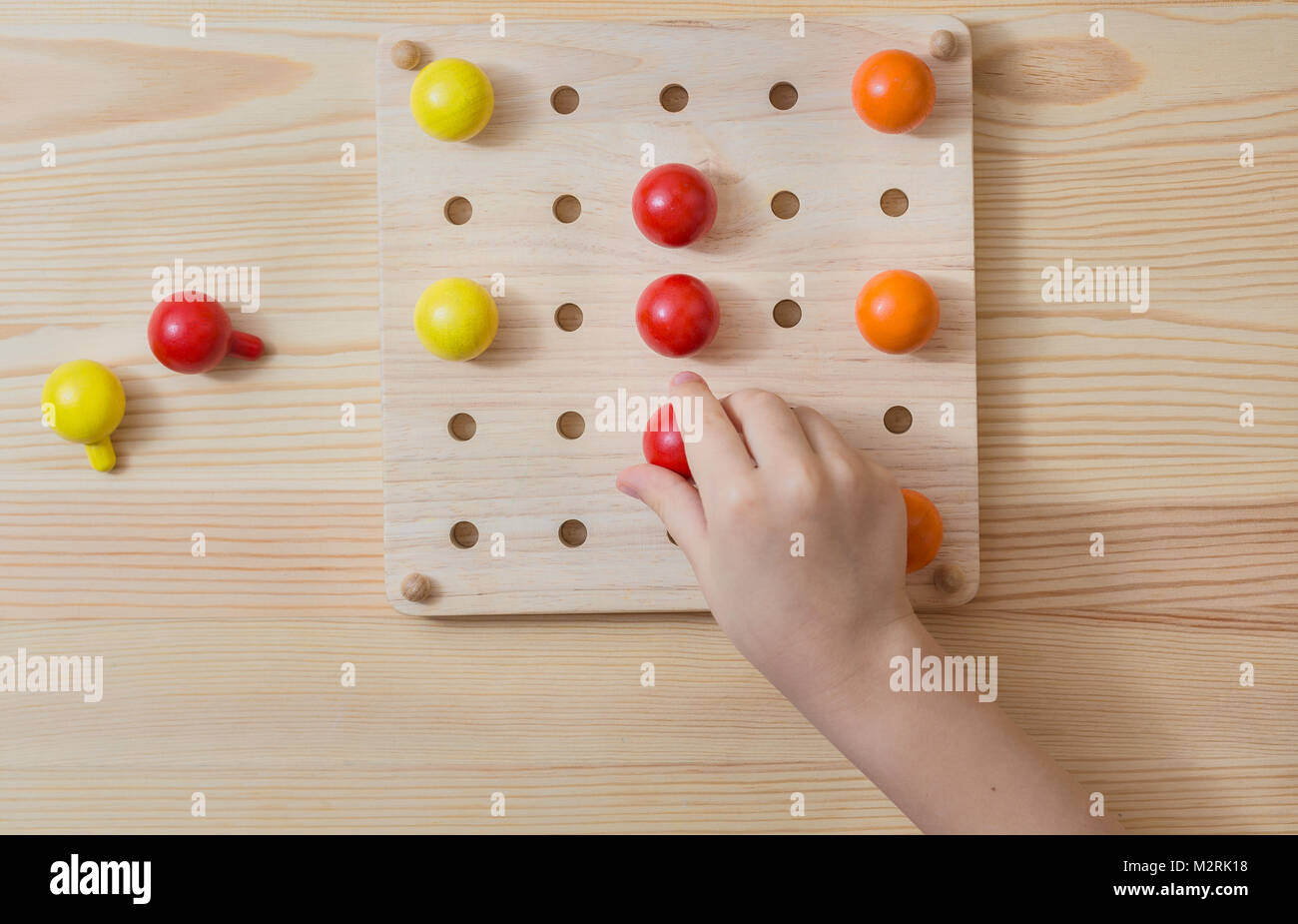 The child is playing with wooden colorful balls. Game for children ...