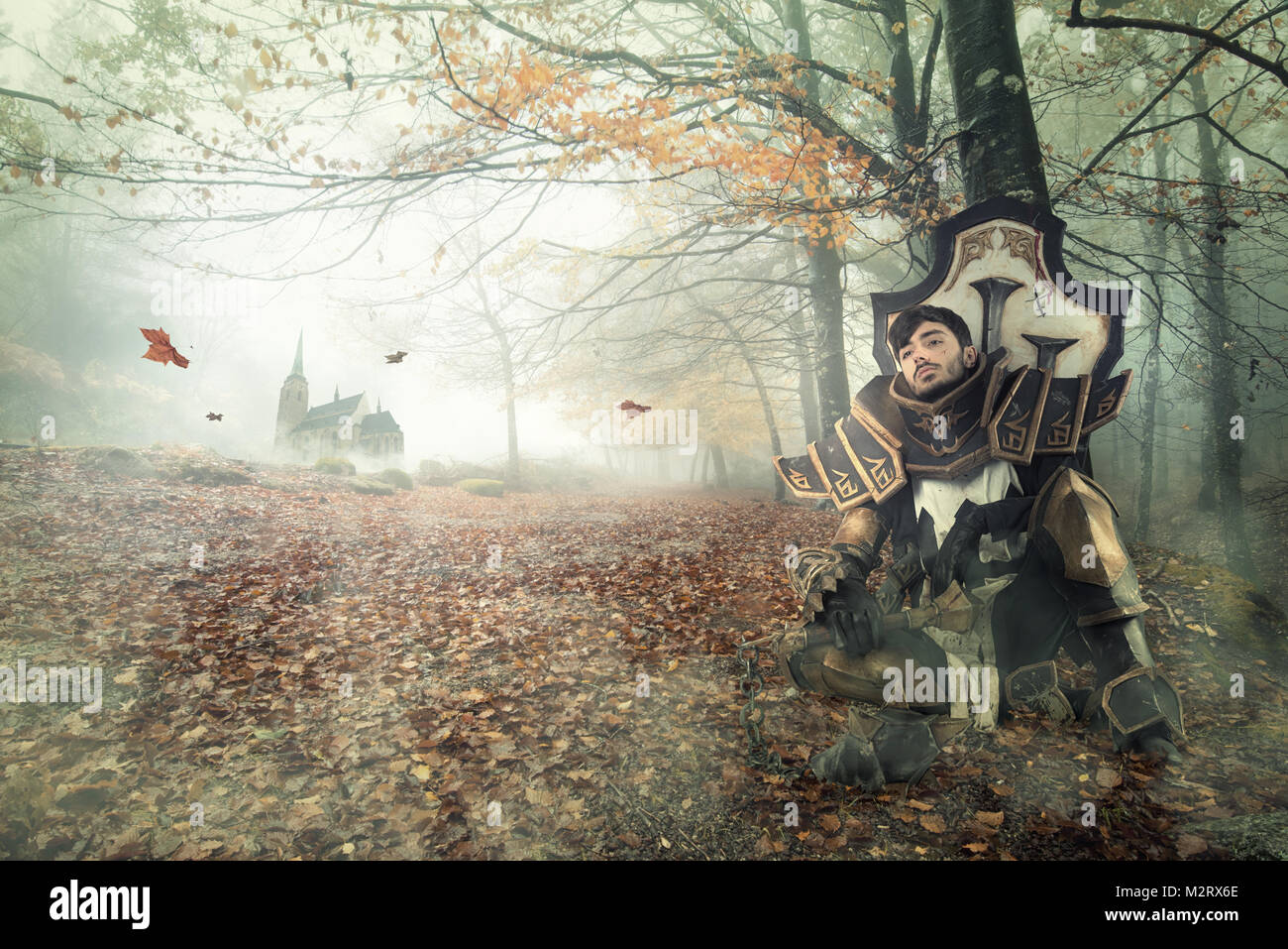 Young man cosplaying with fantasy knight costume resting in a dark ...