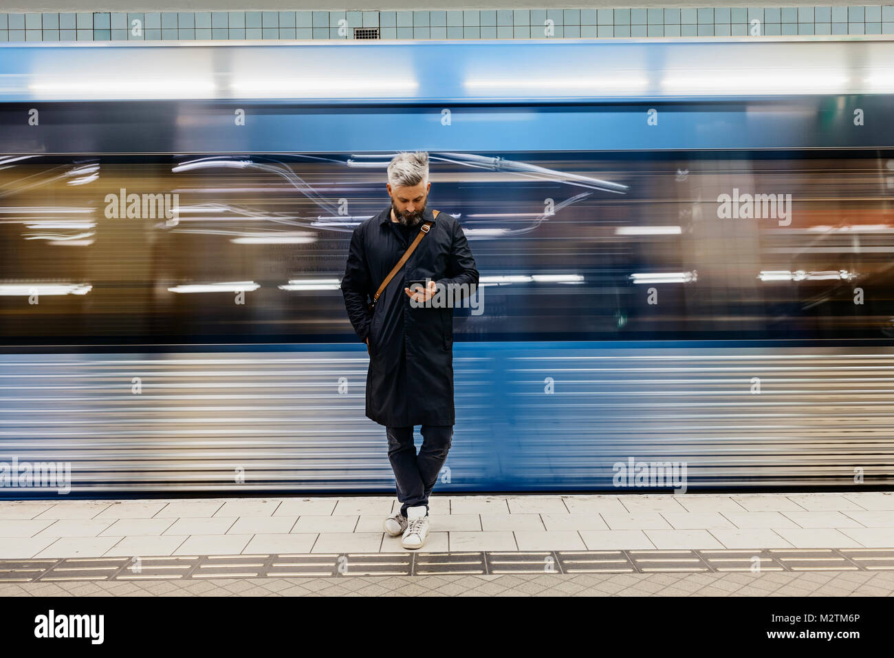 Man texting at train station in Stockholm, Sweden Stock Photo - Alamy