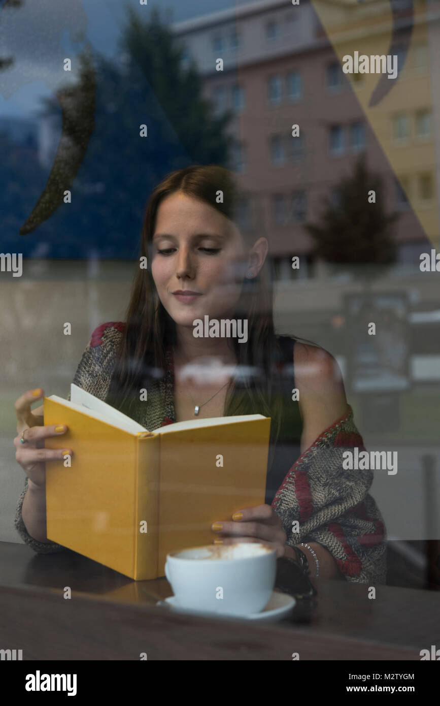 Young woman behind window in the café, semi-portrait Stock Photo - Alamy