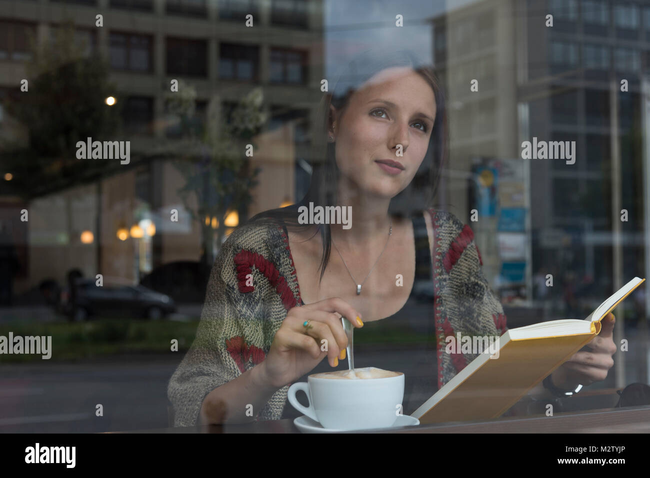 Young woman behind window in the café, semi-portrait Stock Photo - Alamy
