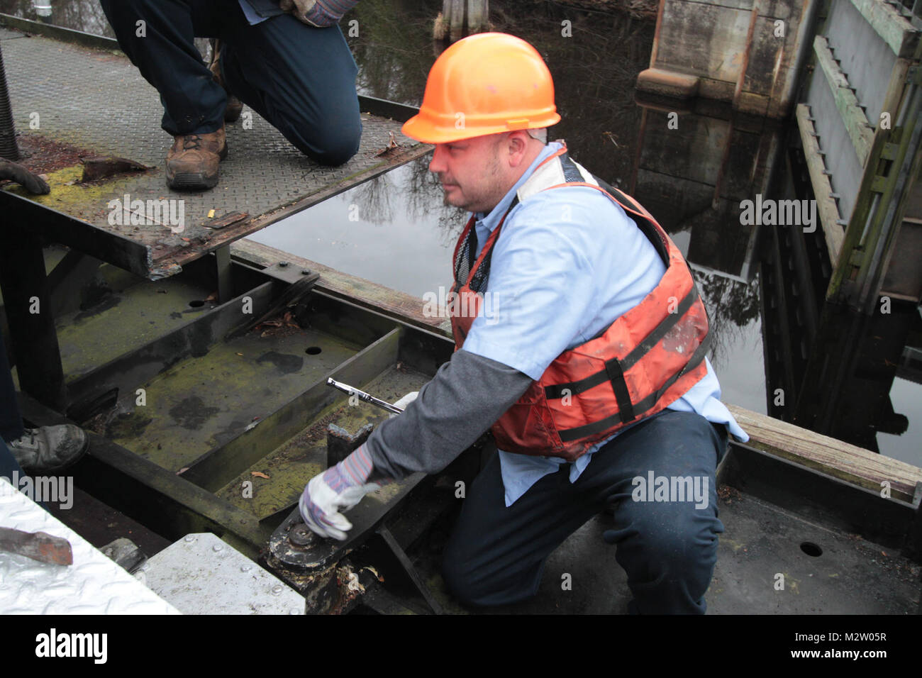 Tommy Hollins disconnects a steel swing arm that opens and closes the ...