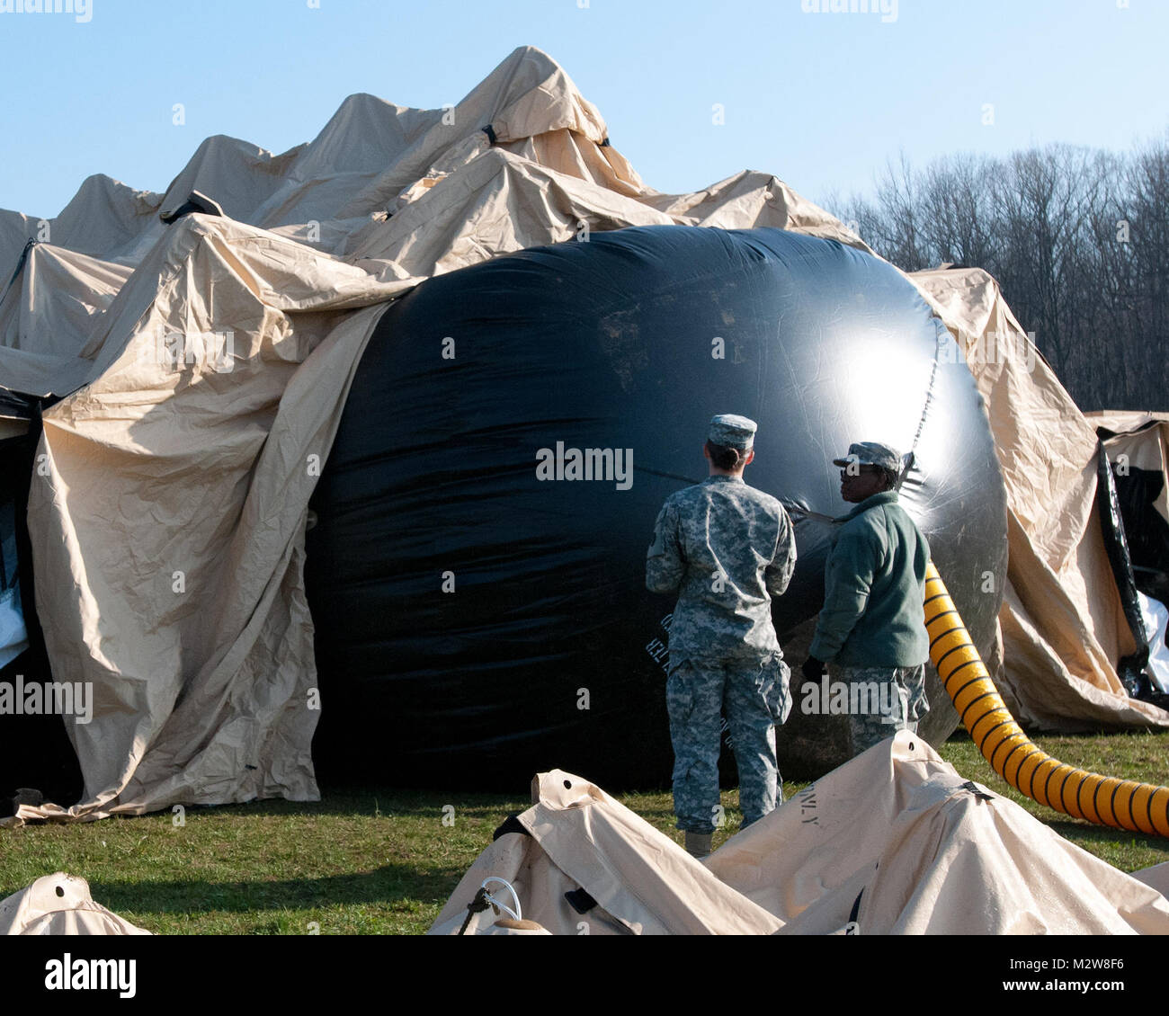 Soldiers of the 316th ESC observe the air bladder filling a large ...
