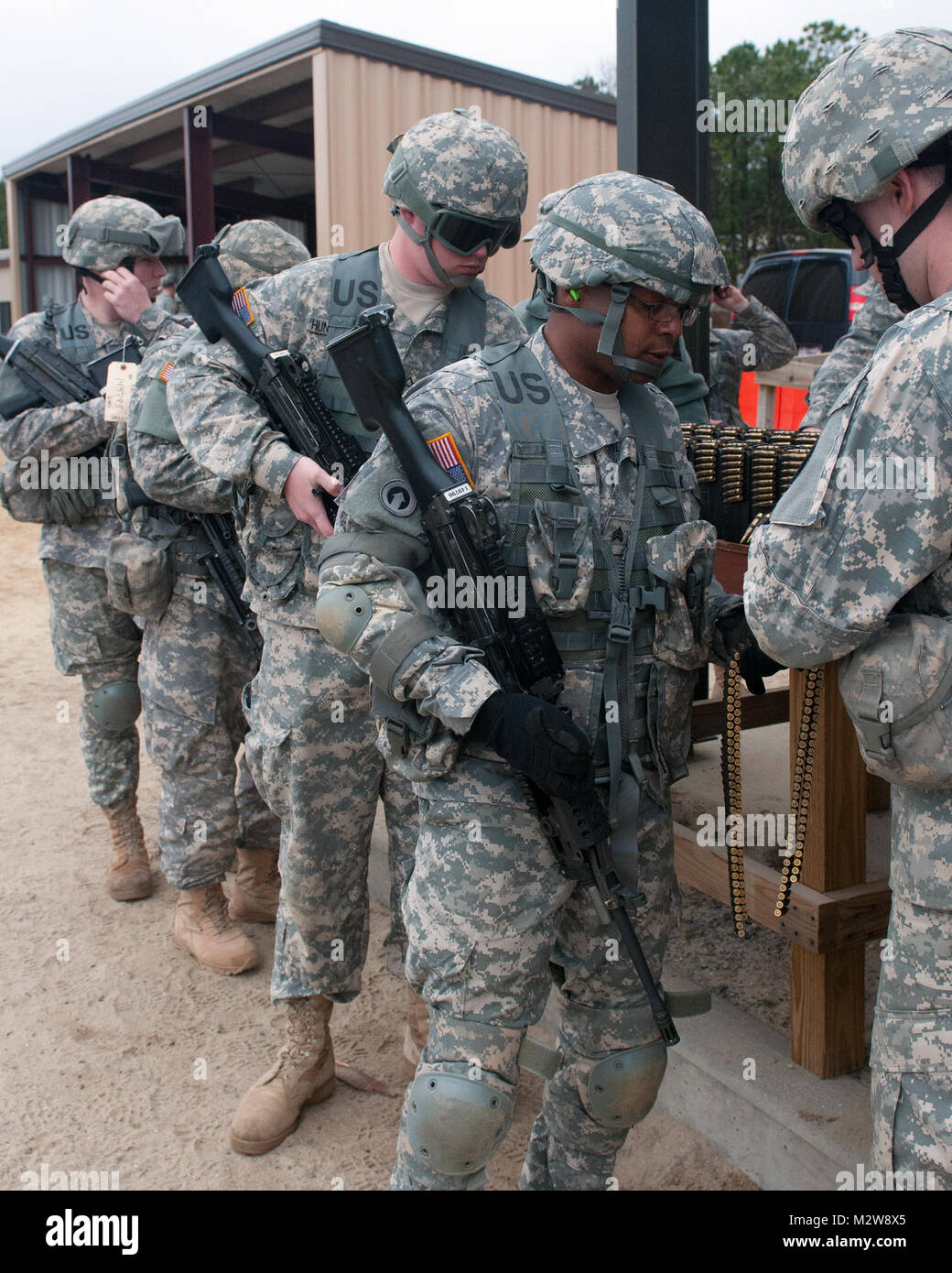 Soldiers of the 316th ESC line up to receive ammunition for the M249 ...