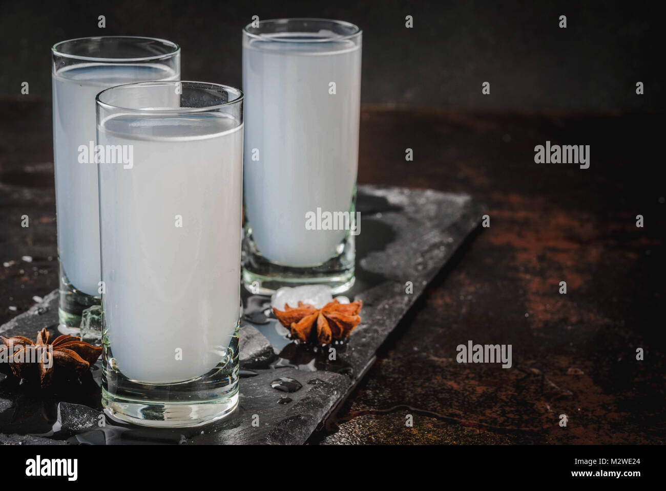 Traditional arabic alcohol drink Raki with anise, dark rusty background ...