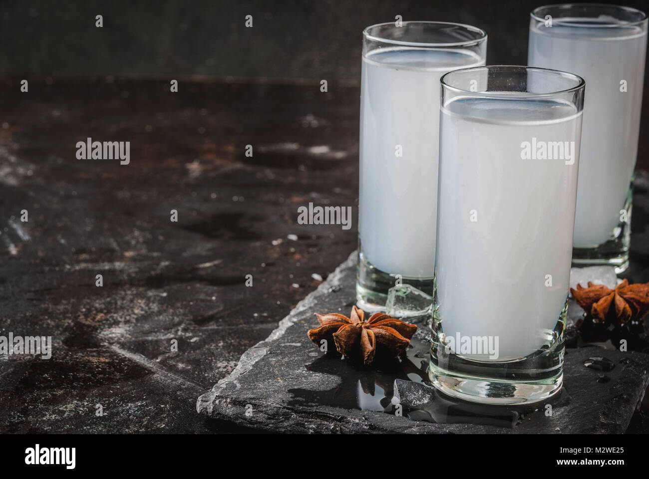 Traditional arabic alcohol drink Raki with anise, dark rusty background ...