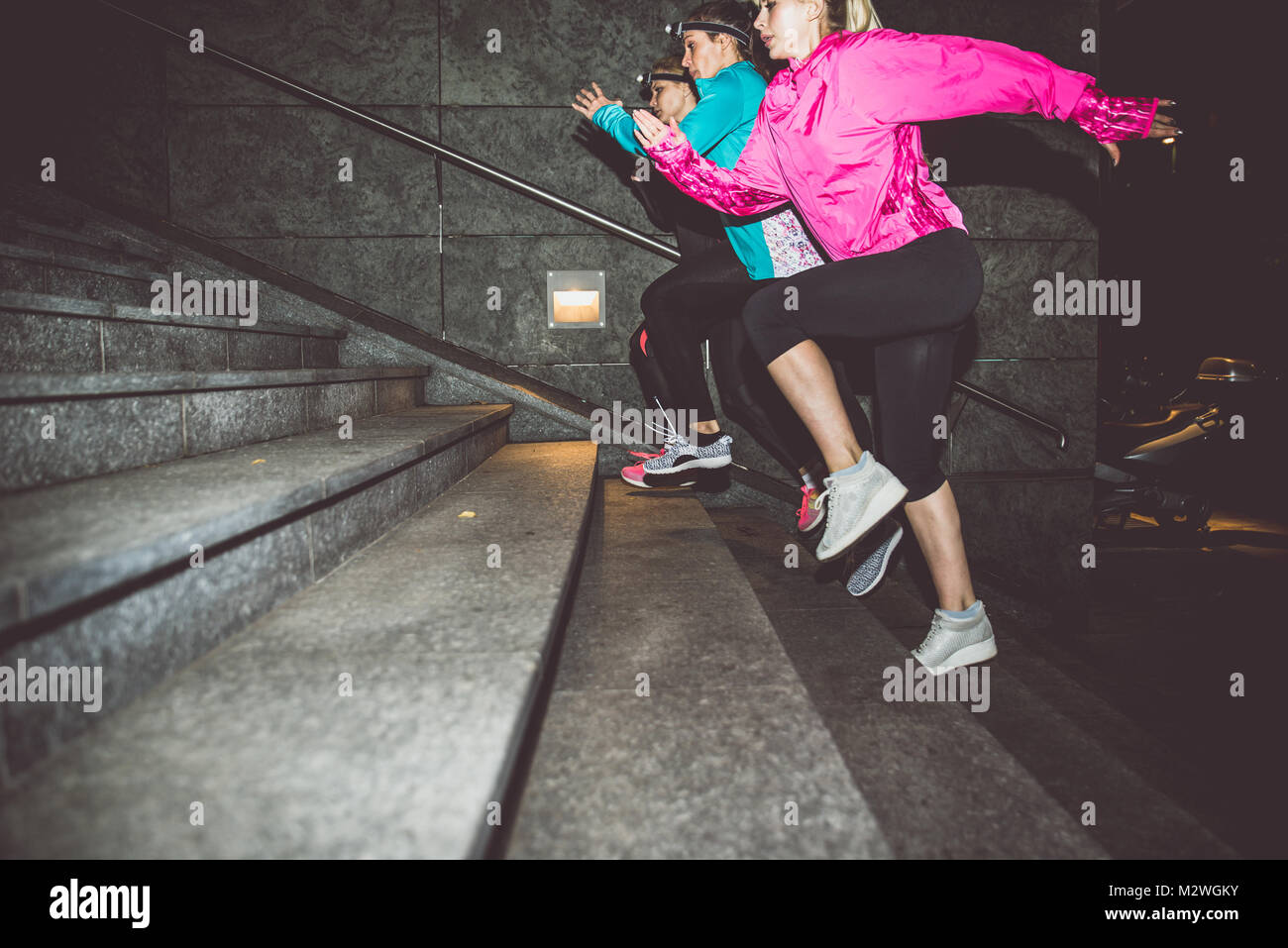 Three women running in the night in the city center Stock Photo - Alamy