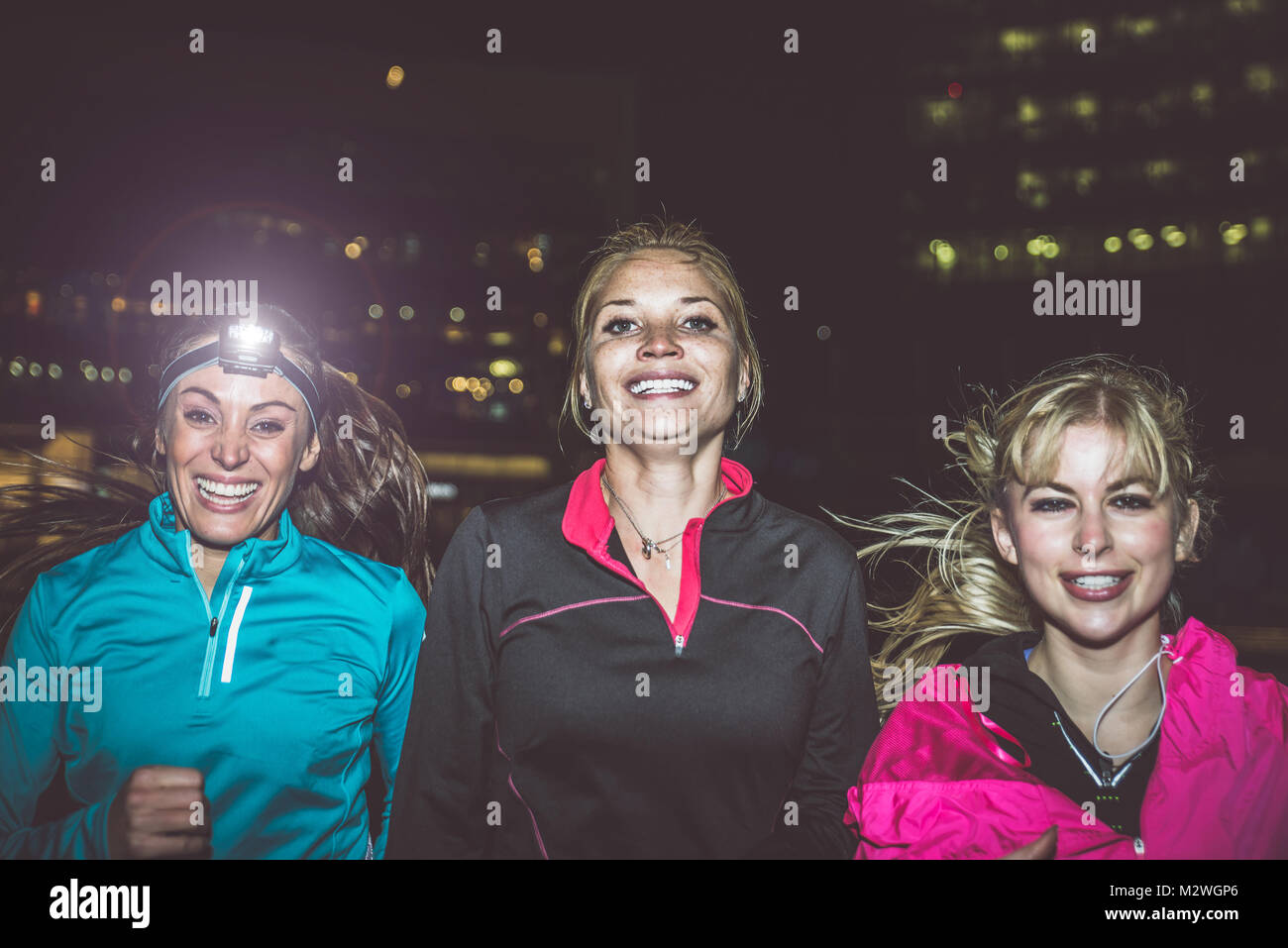 Three women running in the night in the city center Stock Photo - Alamy