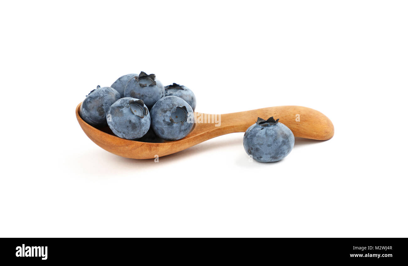 Close up several fresh blueberry berries in one rustic natural wooden ...