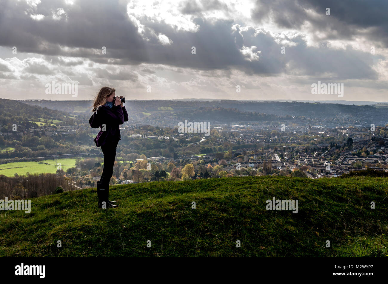 Young woman takes photographs on Little Solsbury Hill, Batheaston, Bath ...