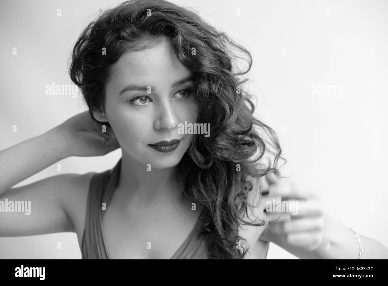 Beautiful classically dressed young girl dances across a grey backdrop ...