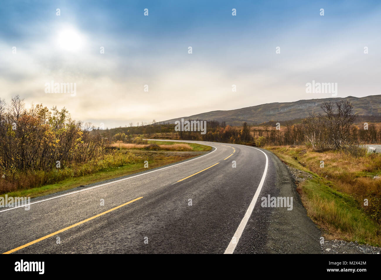 Asphalt sharp curved road along the forest and mountain, Tromso, Norway ...