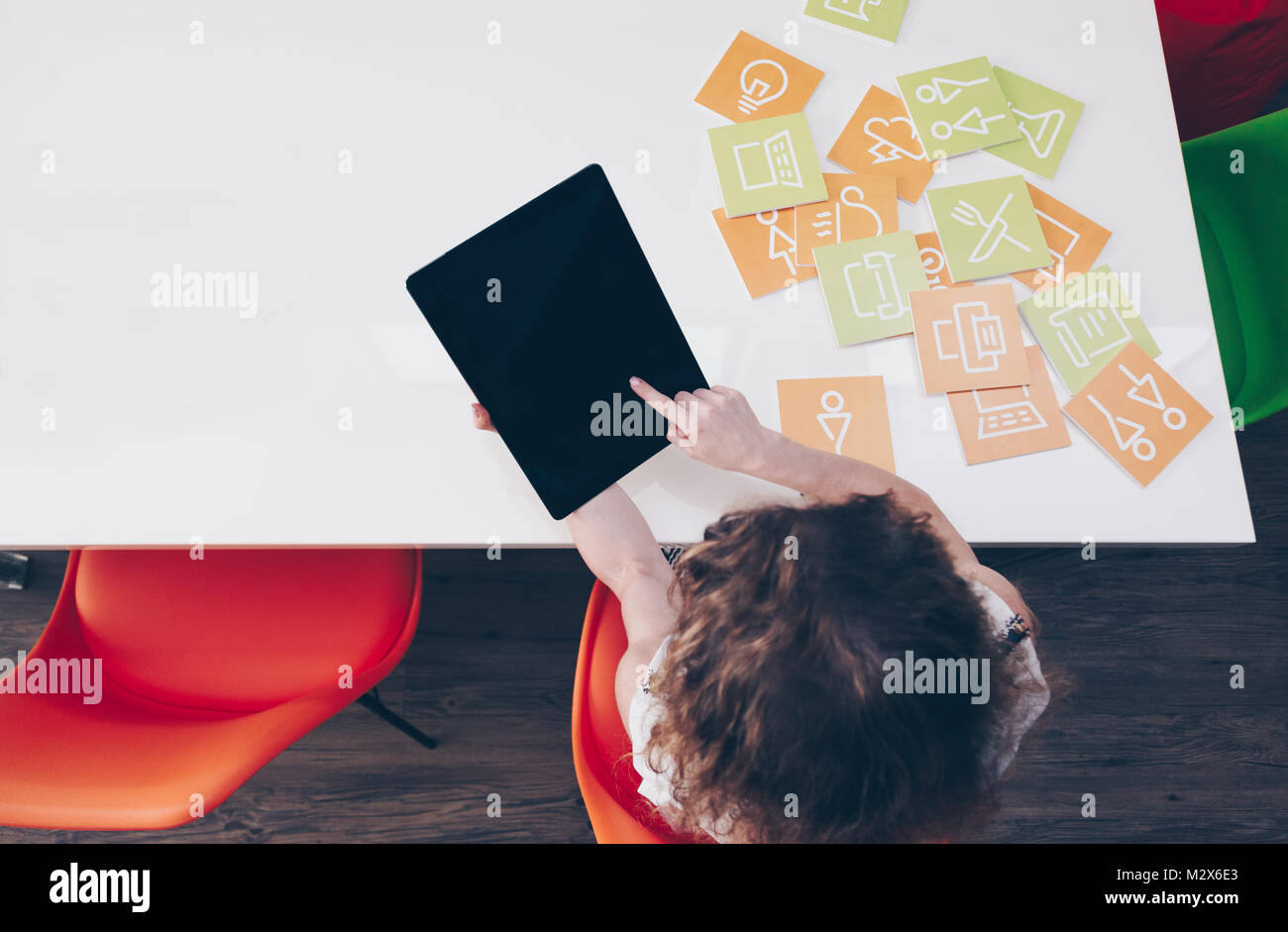 Aerial view of a young girl using a big tablet with touch gesture ...