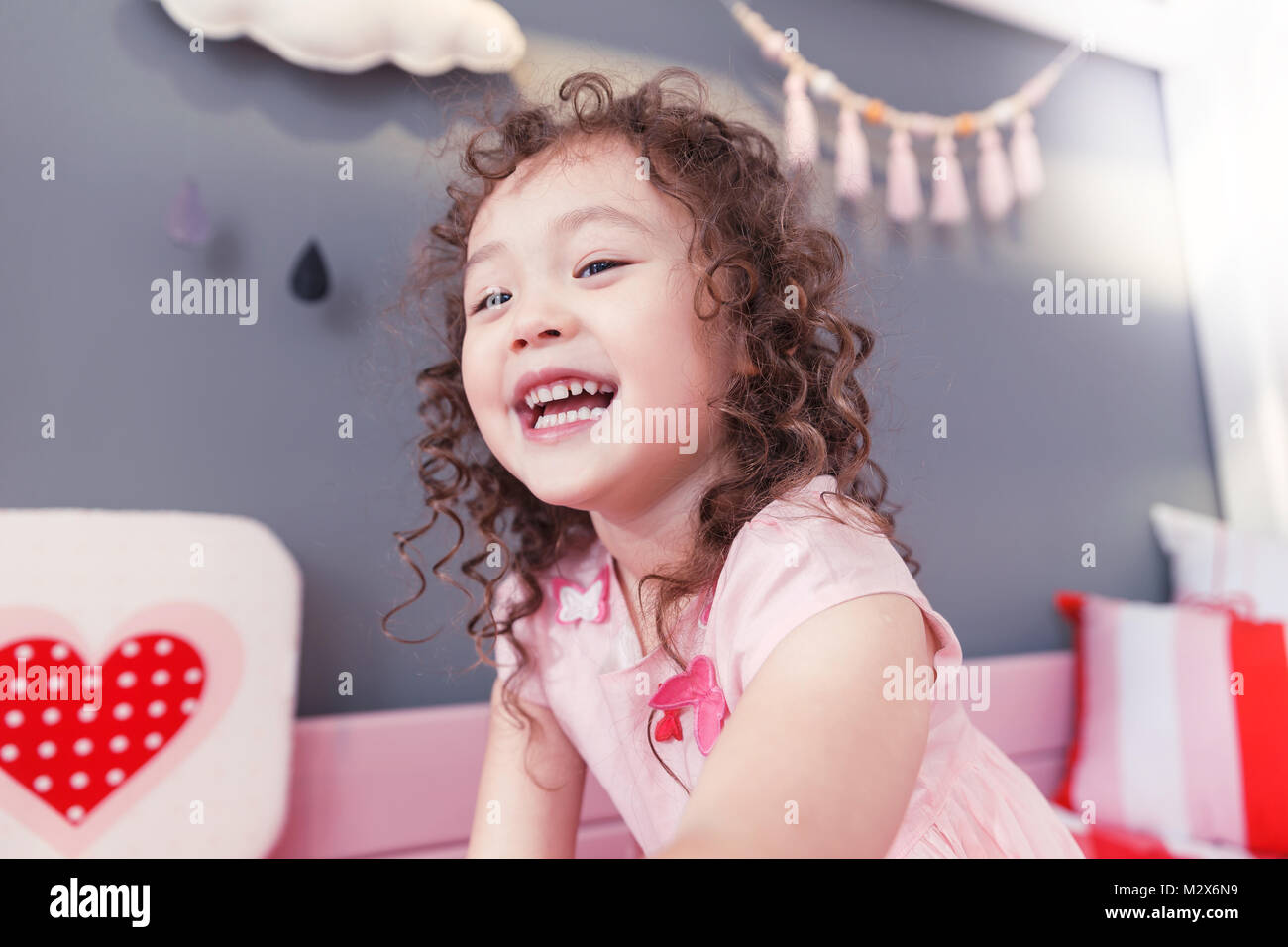 Playing cute girl on the bed Stock Photo - Alamy