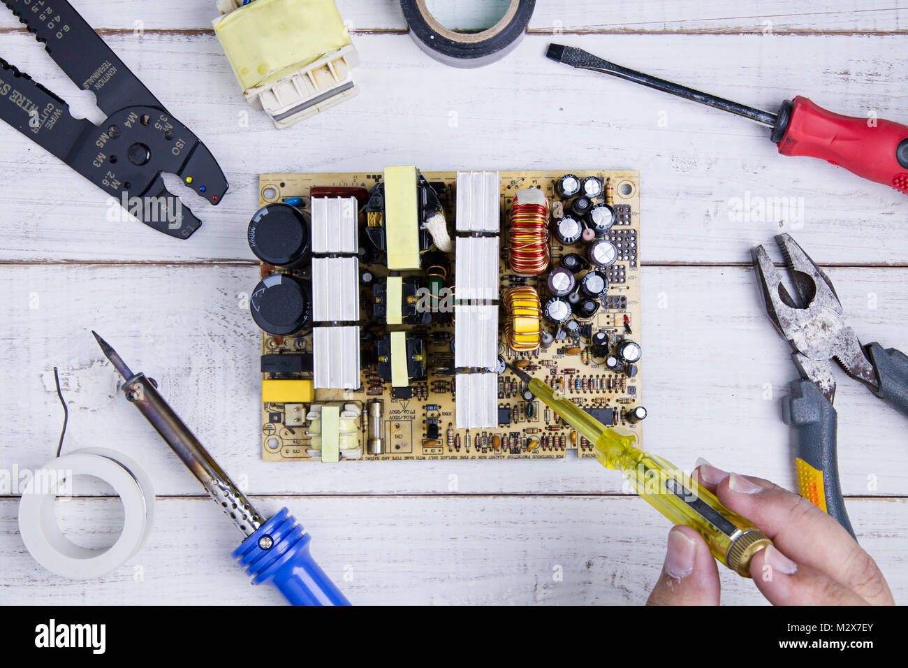 Serviceman check circuit board with electrical tester screwdriver in ...