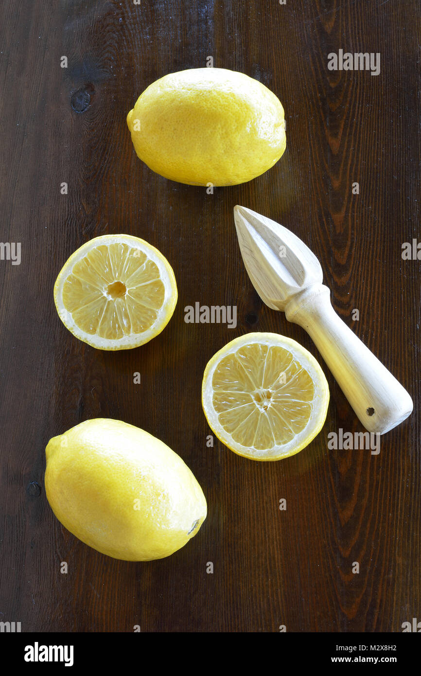 Unwaxed lemons and lemon squeezer on wooden table Stock Photo - Alamy