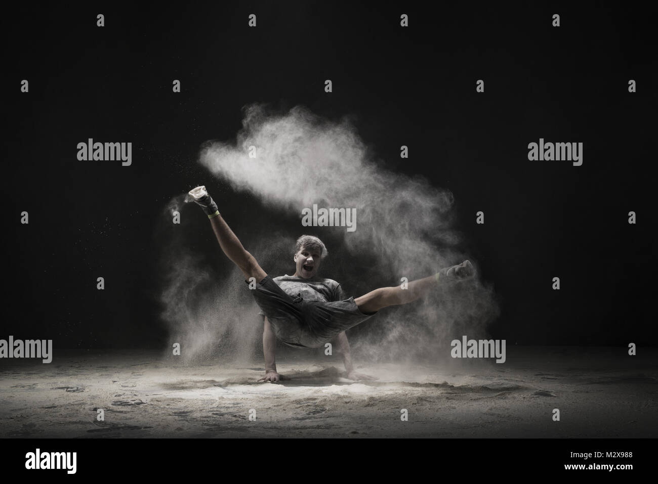 Young men jumping in a cloud of white dust view Stock Photo - Alamy