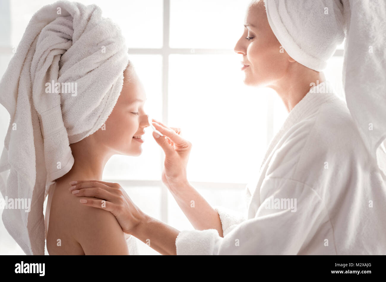 Positive attractive woman caring about her daughter Stock Photo - Alamy