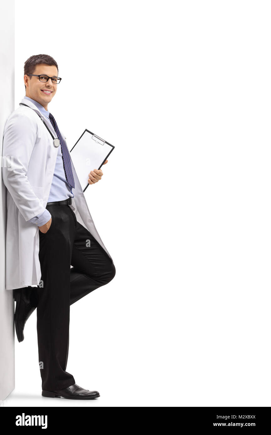 Full length portrait of a doctor leaning against a wall isolated on ...