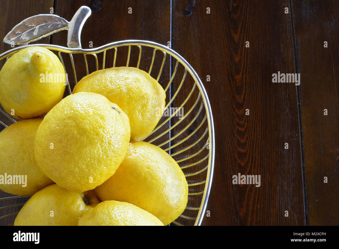Unwaxed lemons in an apple shape chrome bowl Stock Photo - Alamy