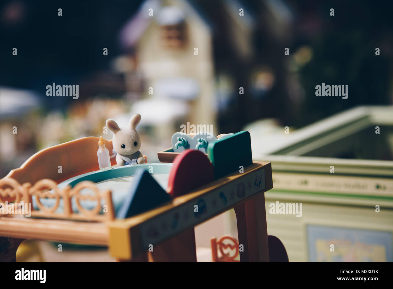Cute toy sitting among a toy house Stock Photo - Alamy