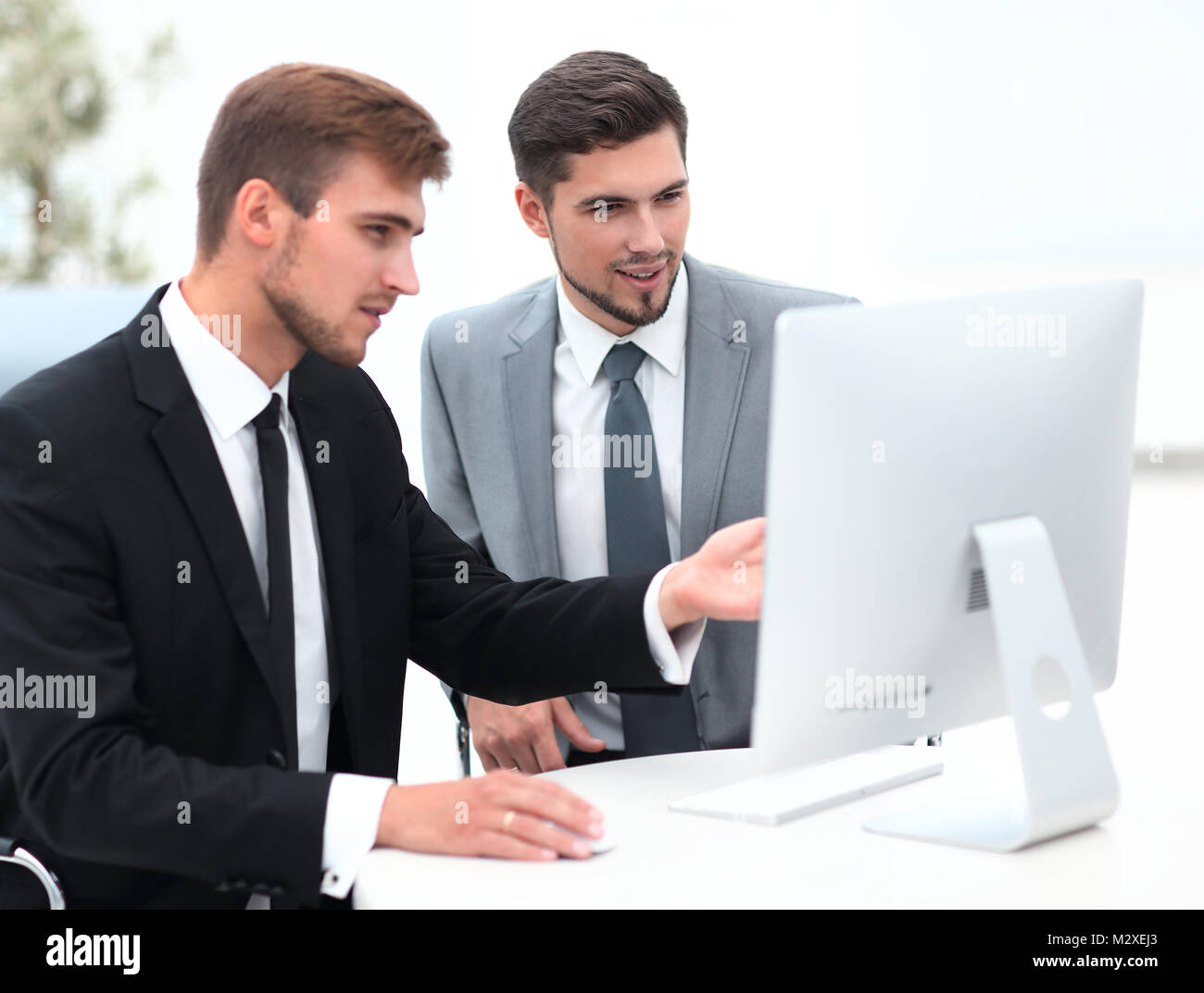 employees are talking sitting behind a Desk Stock Photo - Alamy