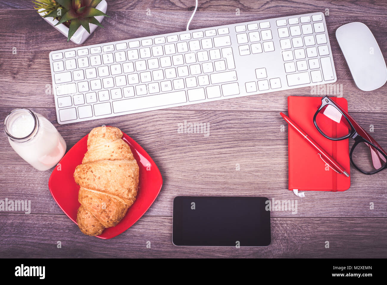 Close up breakfast on the desk. Working table with keyboard, pen, notes ...