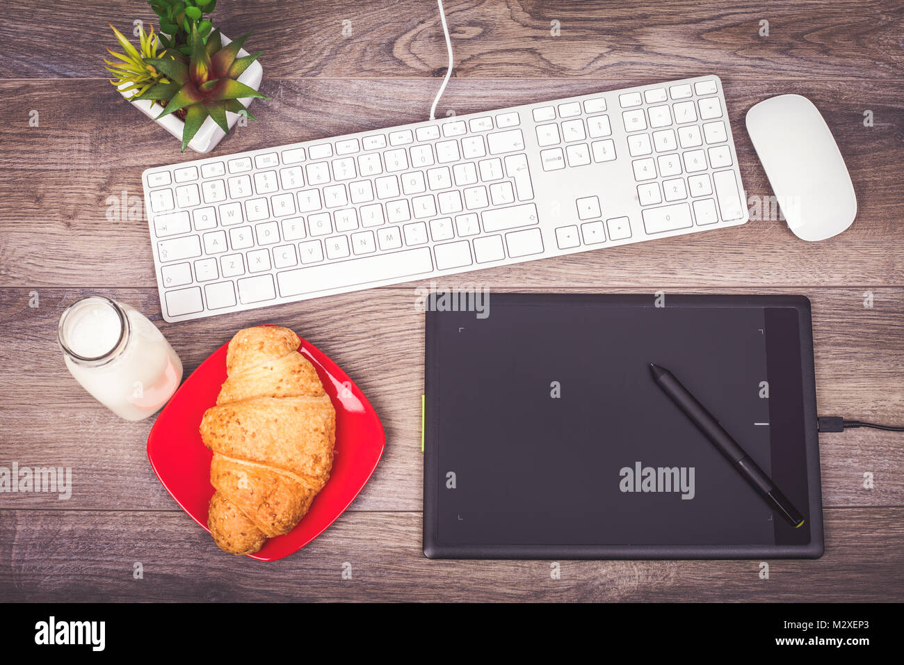 Breakfast on the desk. Working table with keyboard, pen tablet ...
