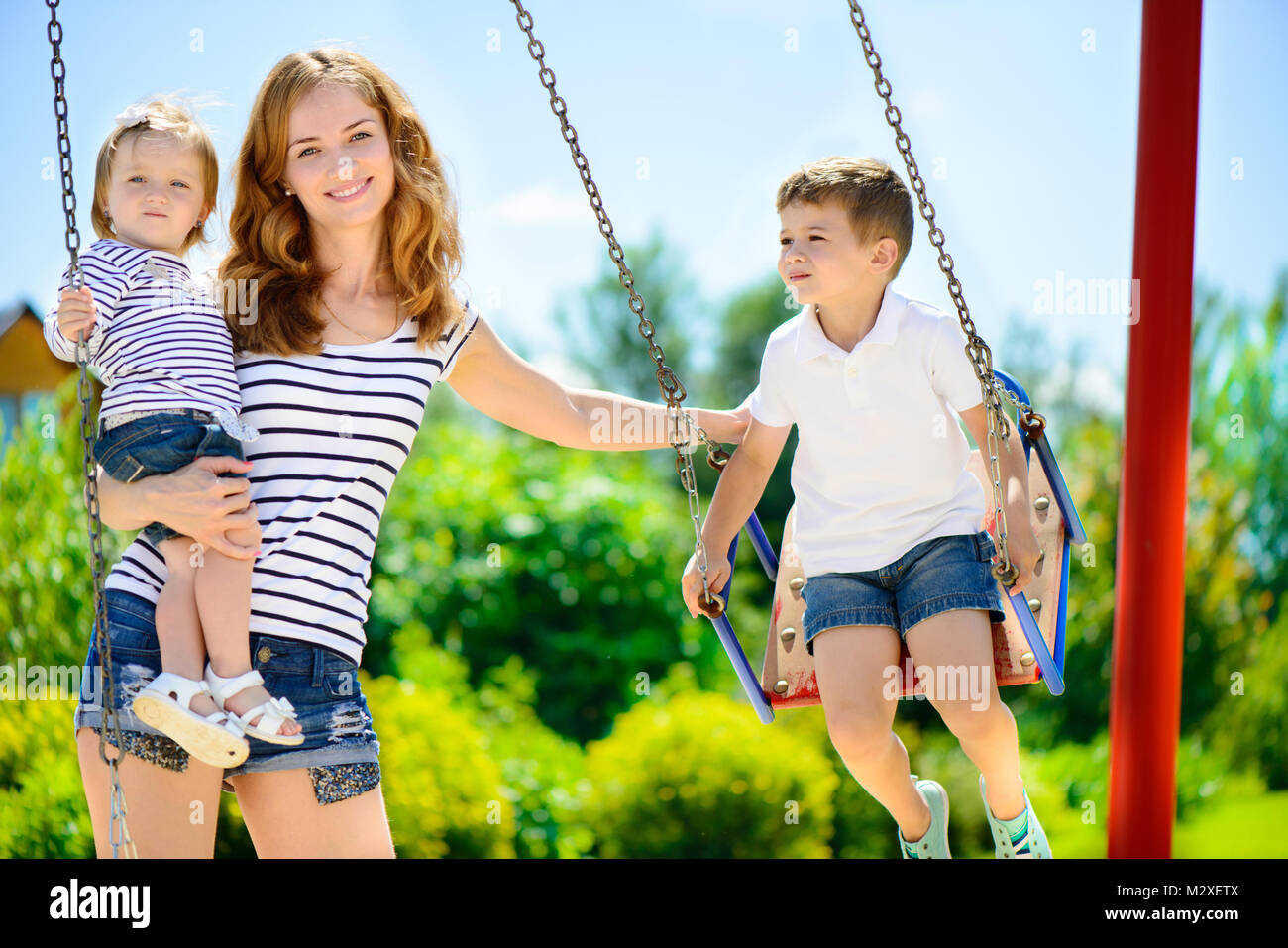 Happy mother and her children on playground Stock Photo - Alamy
