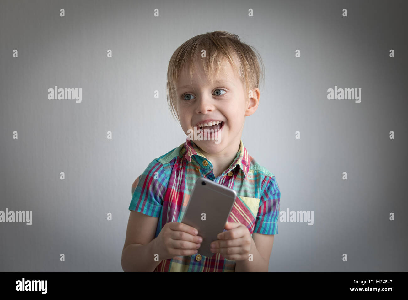 little boy with a smartphone in his hands. childs portrait Stock Photo ...