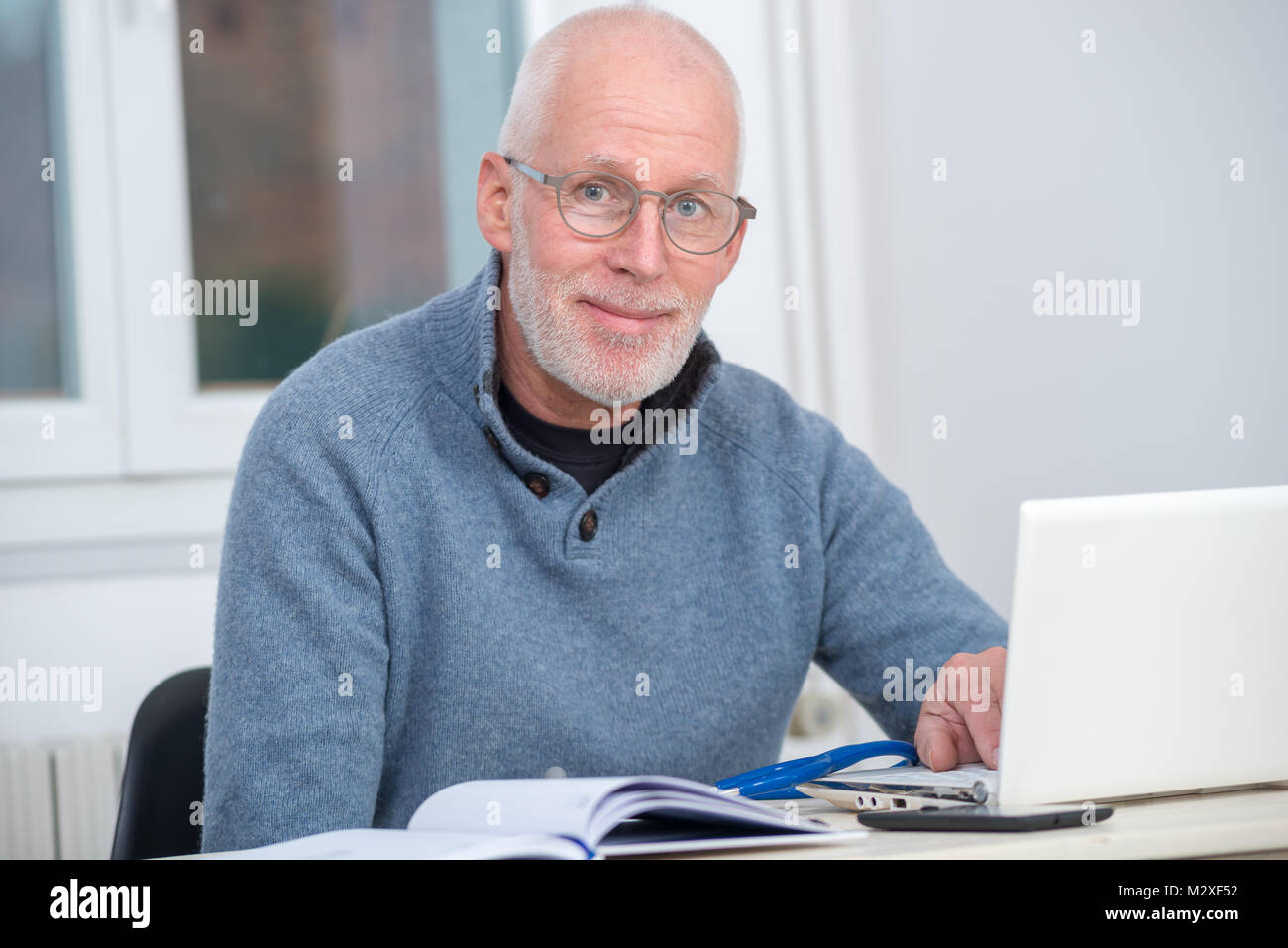 a middle-aged man using laptop in his office Stock Photo - Alamy