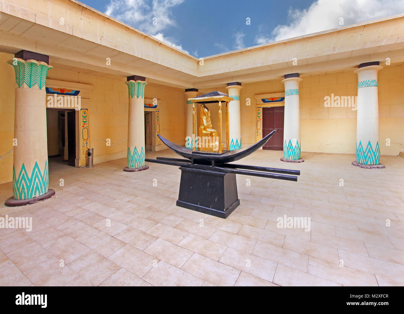 Egyptian temple courtyard with gold statue in center Stock Photo - Alamy