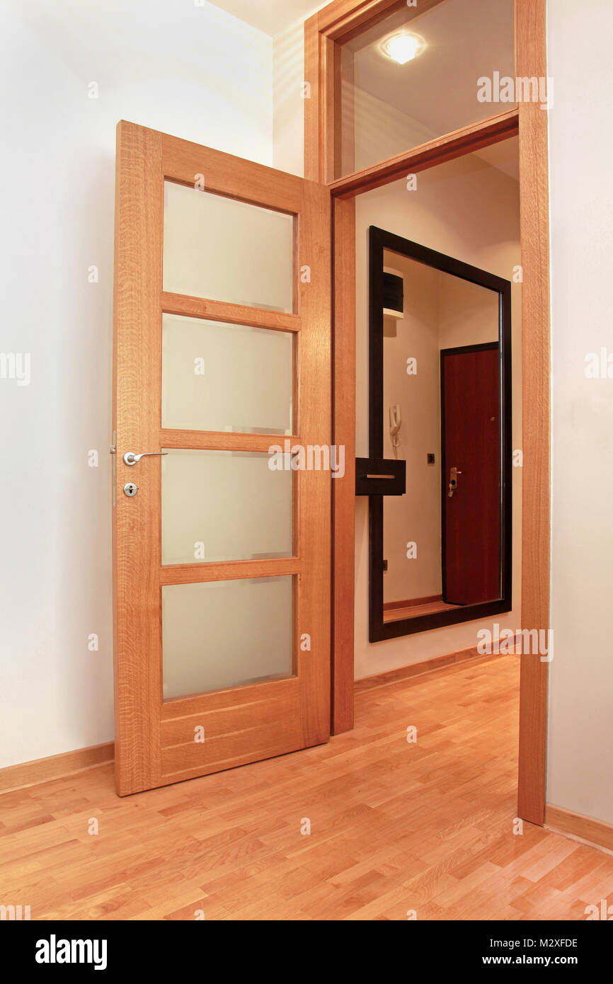 Home interior with open wooden door to corridor Stock Photo - Alamy