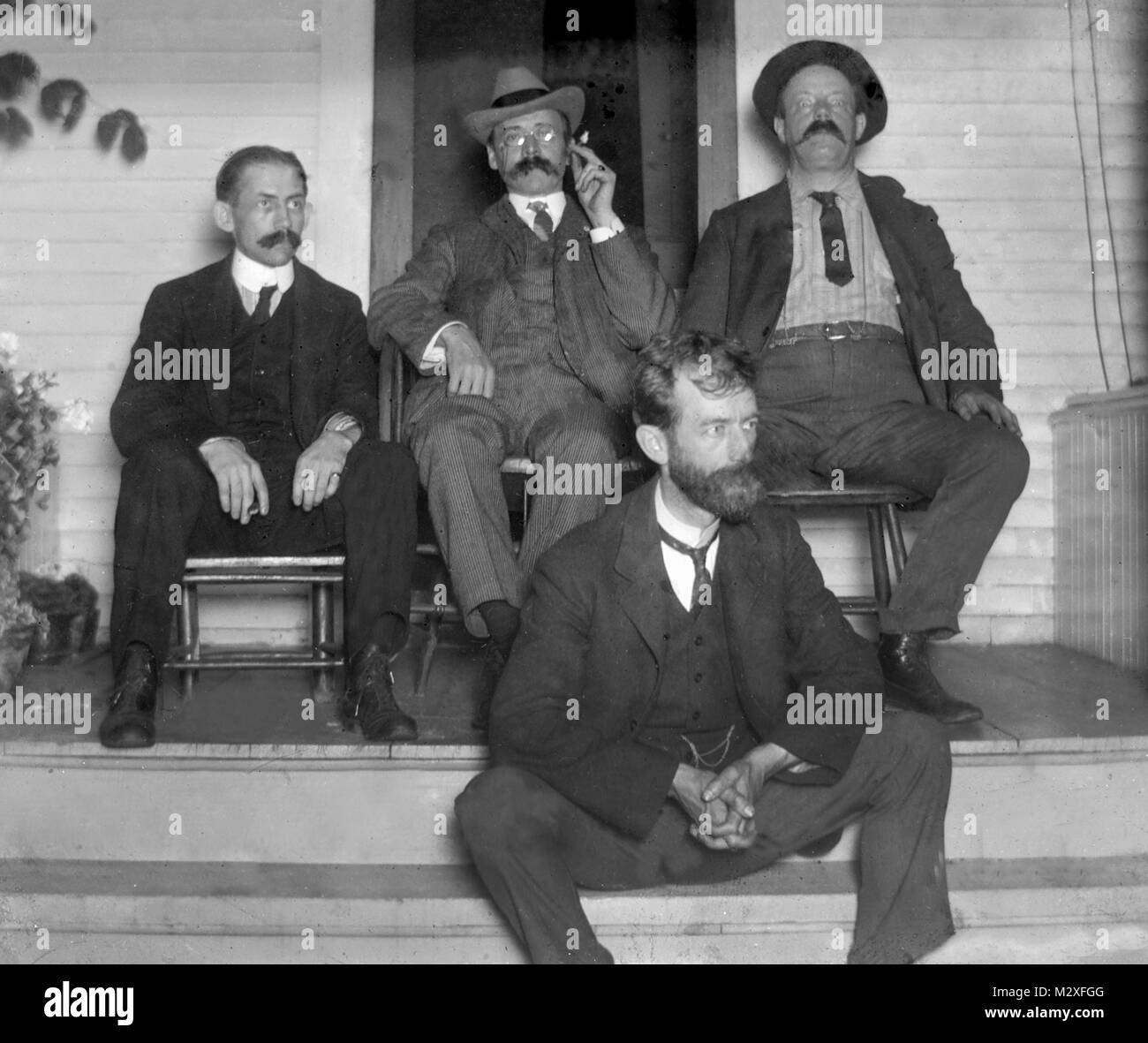 Four men sitting Black and White Stock Photos & Images - Alamy