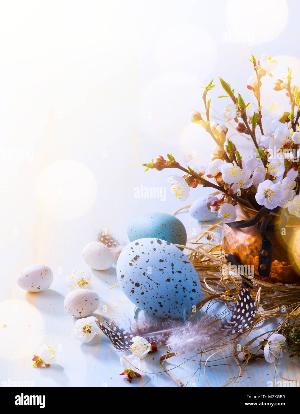 Happy Easter; Easter eggs and sprig flowers on blue table background ...