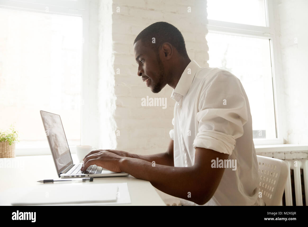 African Businessman Working On Laptop Sitting At Home Office Desk