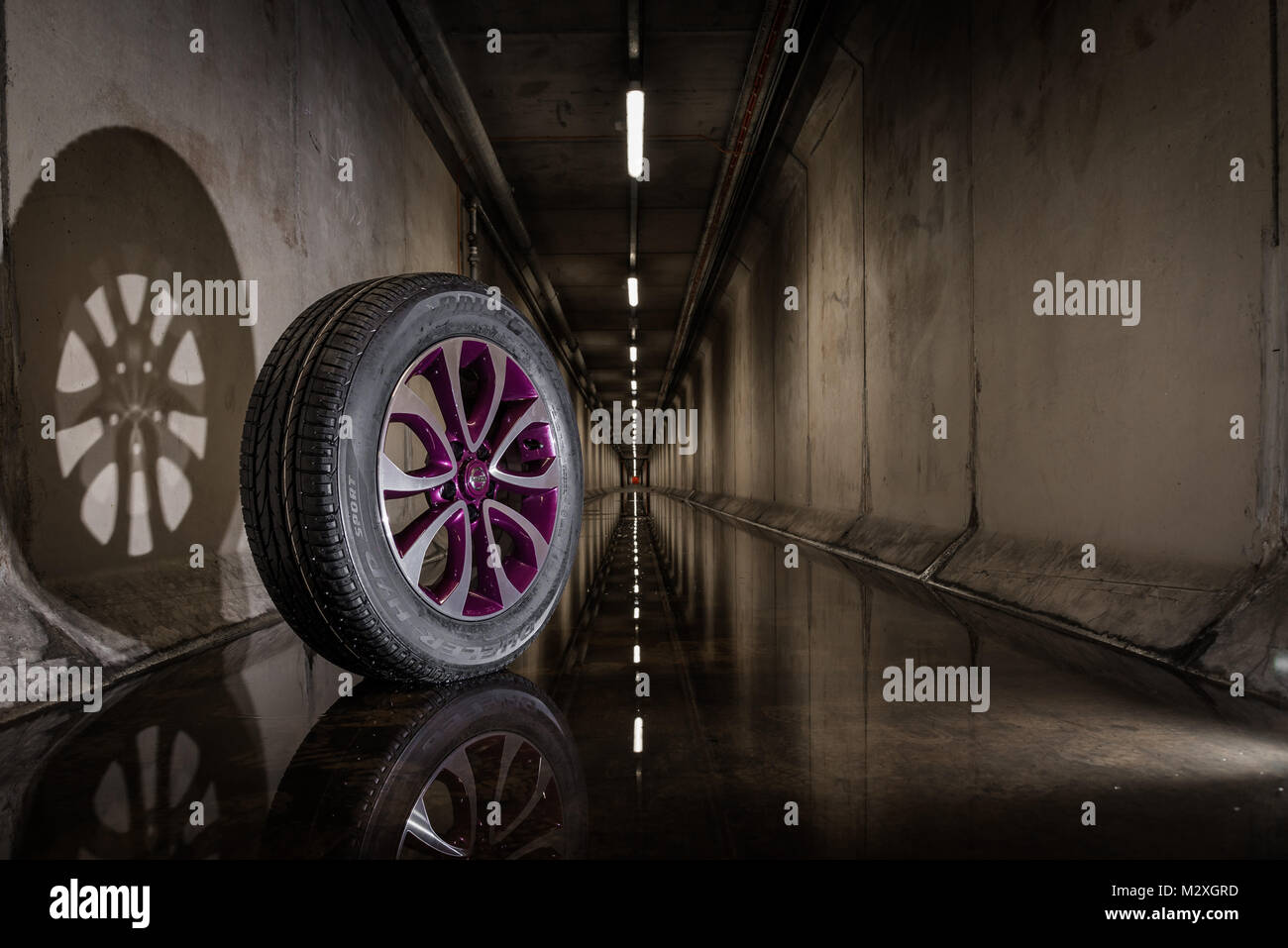 Nissan Juke purple wheel with Bridgestone Tyre in a dimly lit tunnel ...