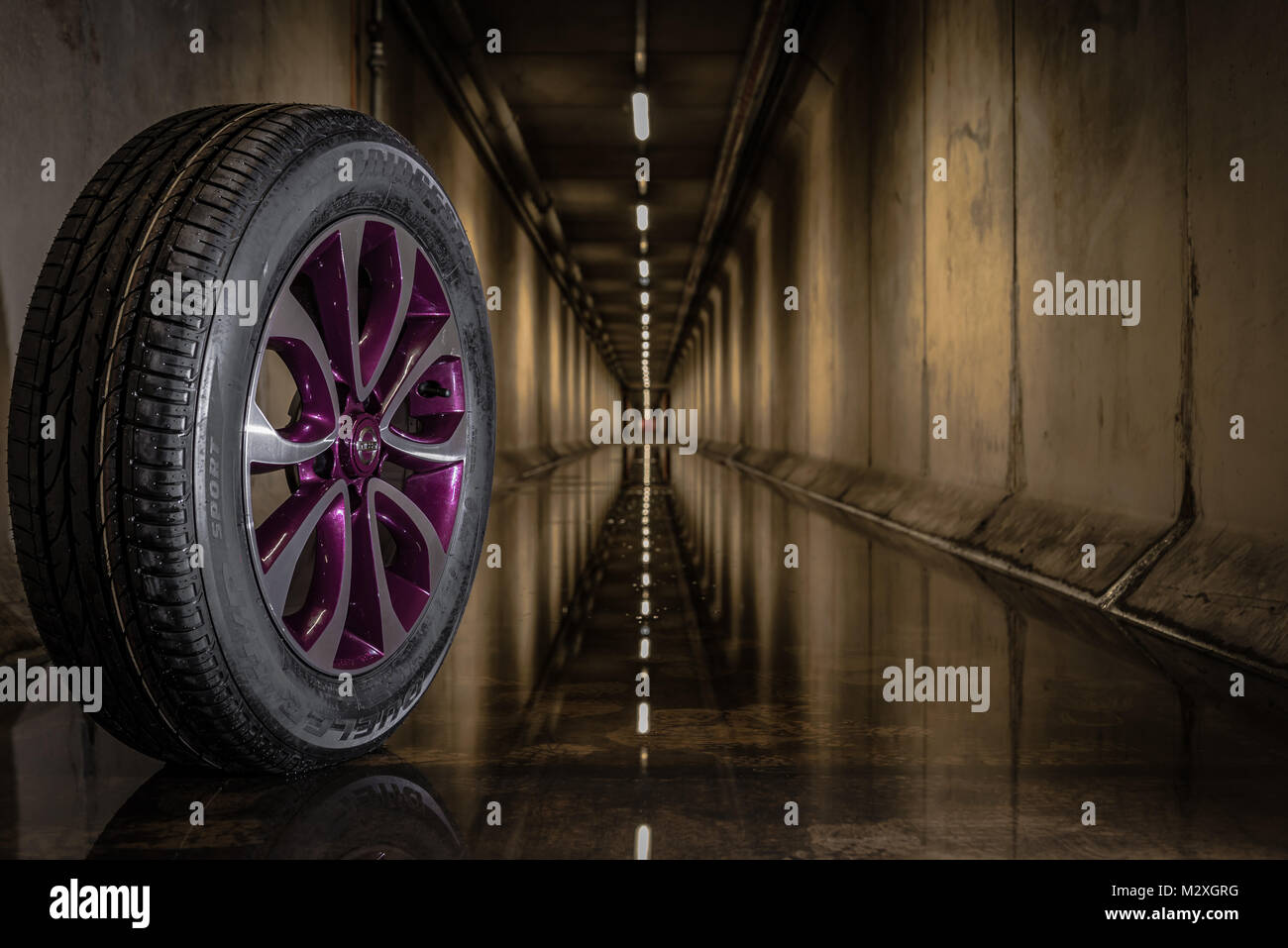 Nissan Juke purple wheel with Bridgestone Tyre in a dimly lit tunnel ...