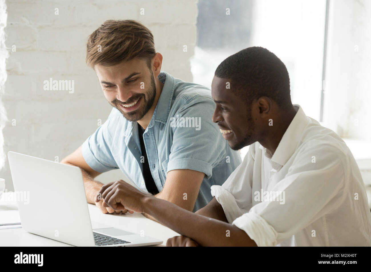 Diverse smiling businessmen having fun laughing working on lapto Stock ...