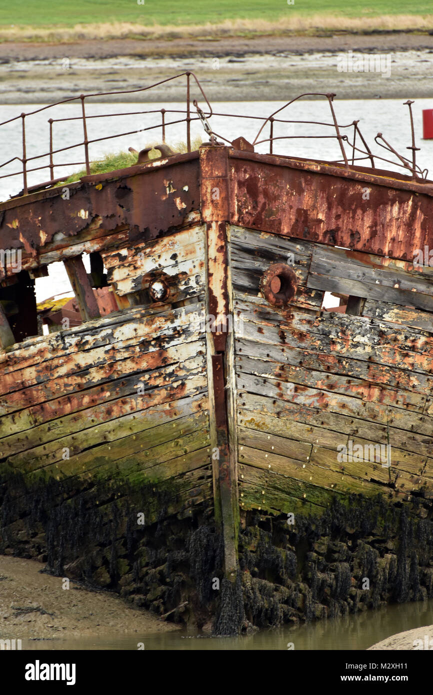 the bows of an old shipwreck or hulk rotting away in the mud at low ...