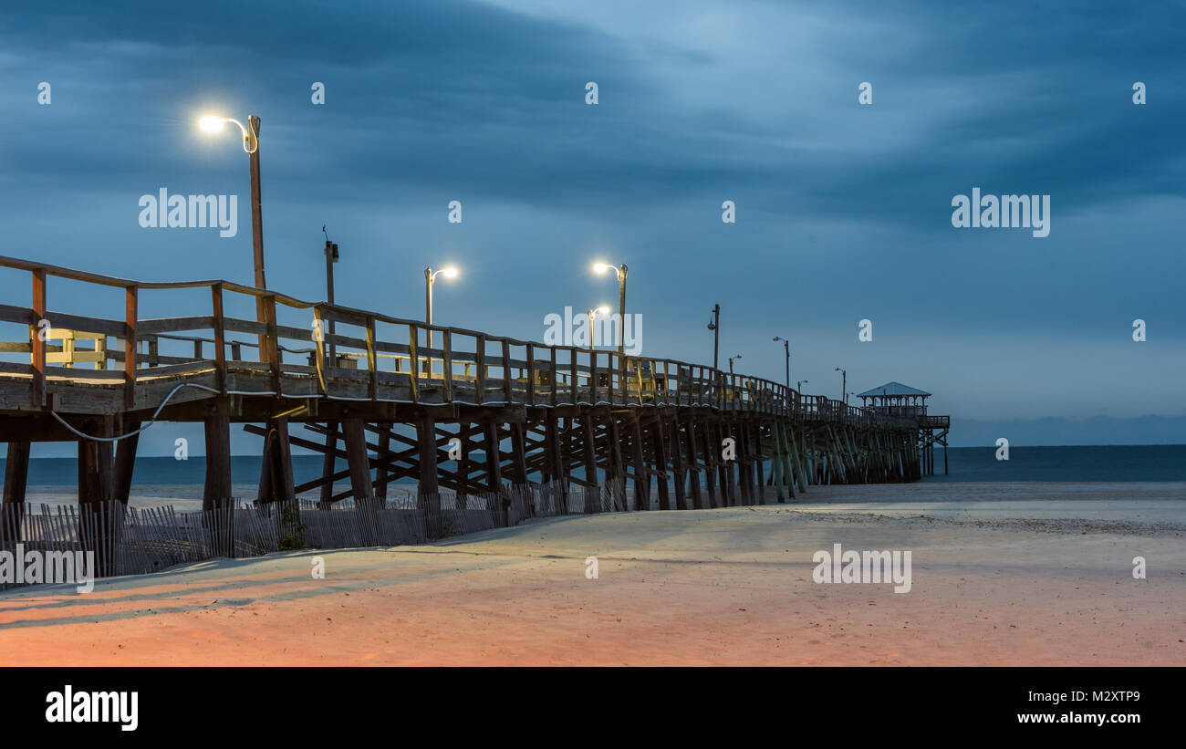 Sunrise with the Atlantic Beach pier in the background with sand, ocean ...