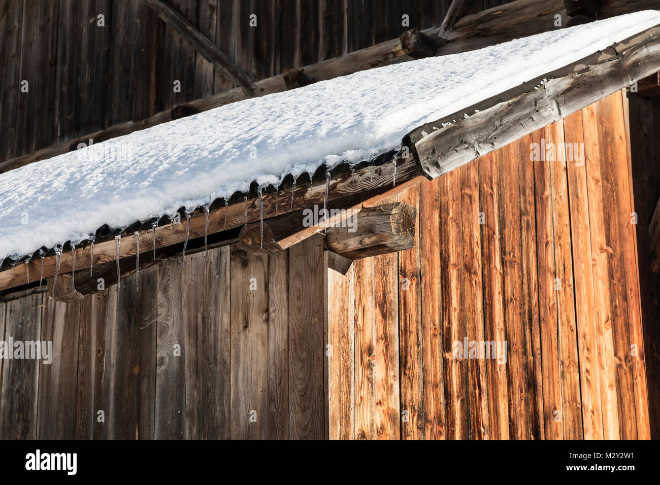 An alpine wooden barn on a winter's morning with snow and icicles Stock ...